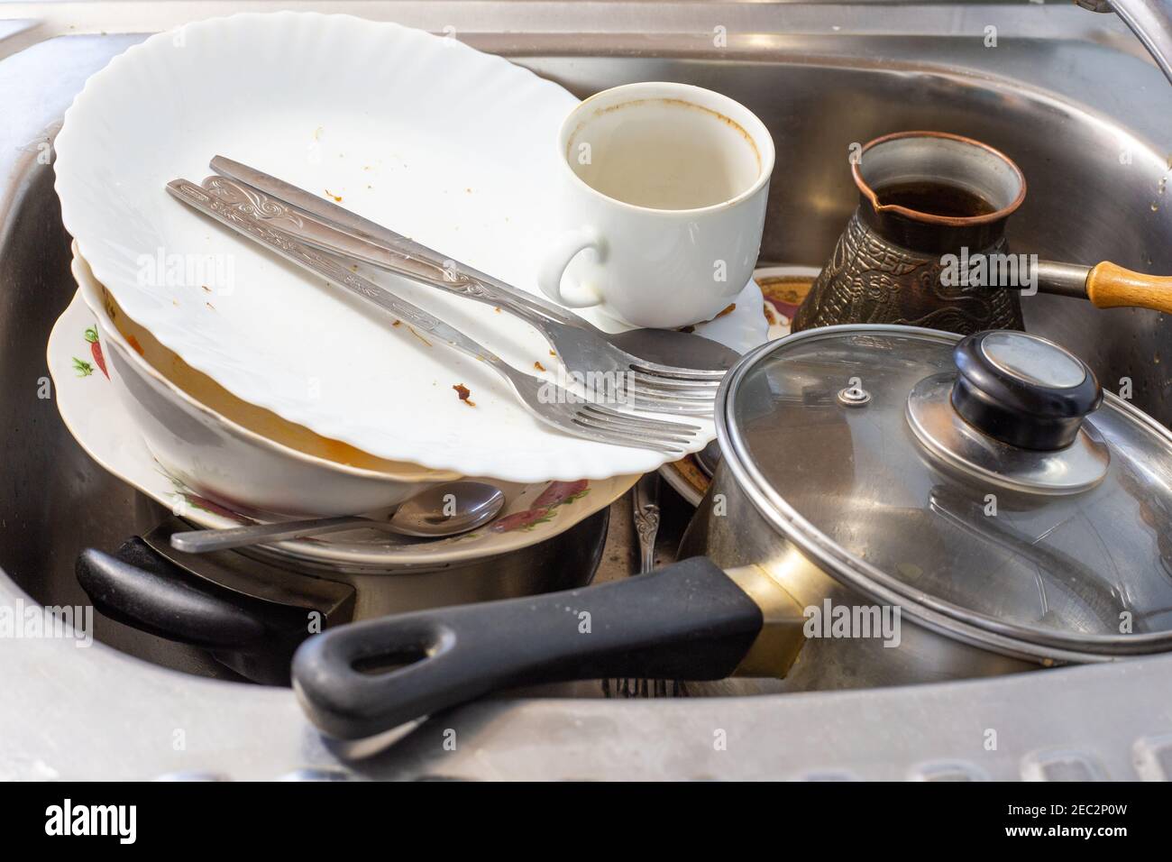 dirty dishes after dinner lie in the sink, cleaning the table in the ...