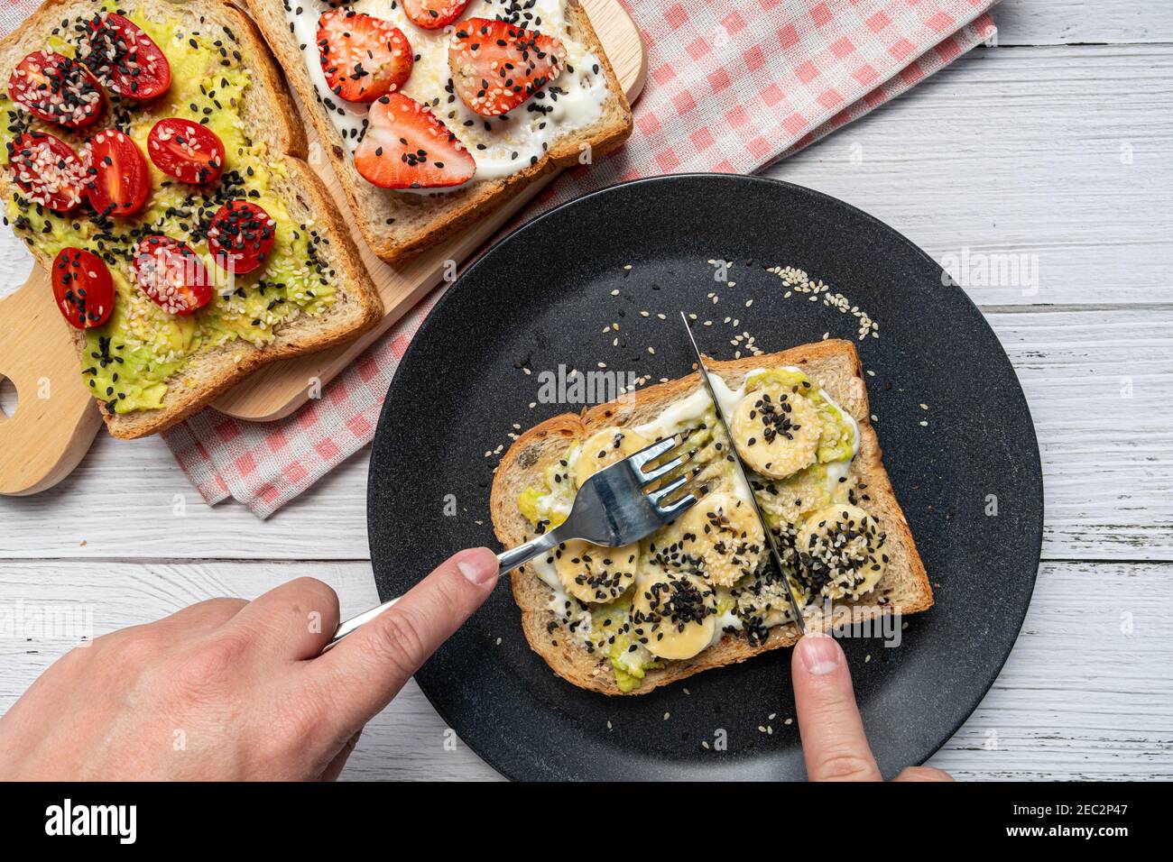 The hand was using a knife and fork to cut the banana Toast. Concept of ...