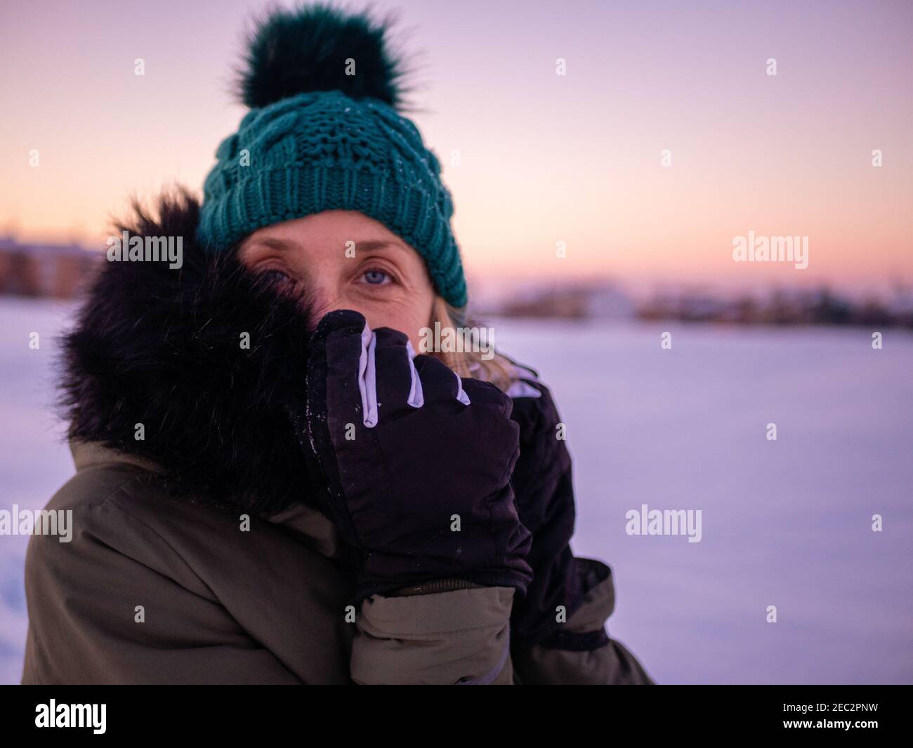Shallow focus shot of a female covering her neck with her furry hood ...