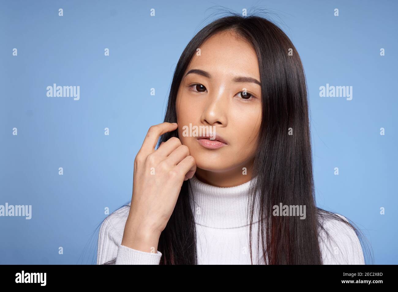 woman asian appearance portrait on blue background white sweater model ...