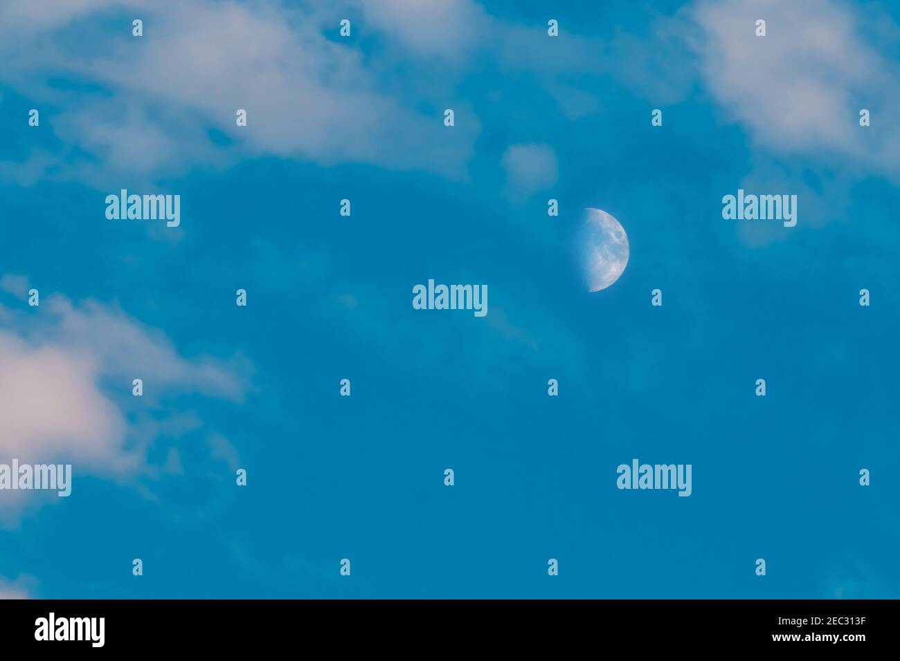 Half waning moon on background of cloudy blue sky in daytime Stock ...