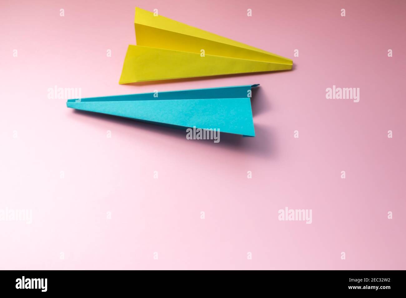 Two flying paper planes over pink paper background. Plane as symbol of ...