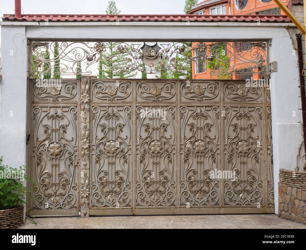 A gate with elaborate wrought-iron decor of many monograms with patina ...
