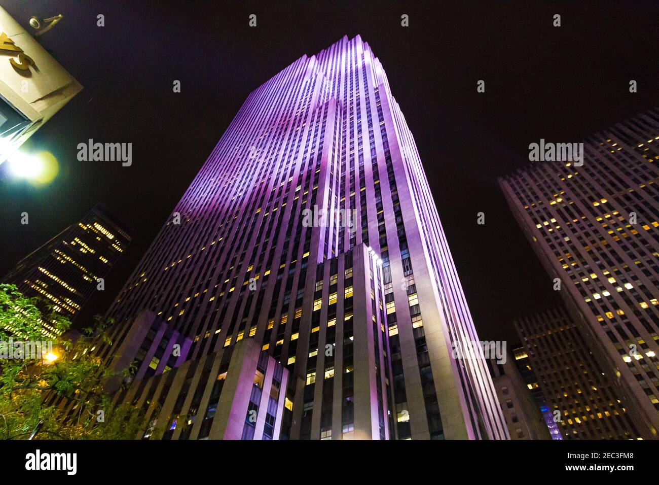 Rockefeller Center in New York at night seen from below with purple ...