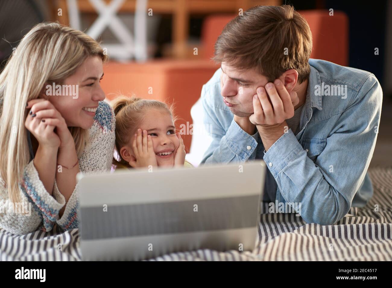 Parents playing together with their daughter on the computer Stock ...