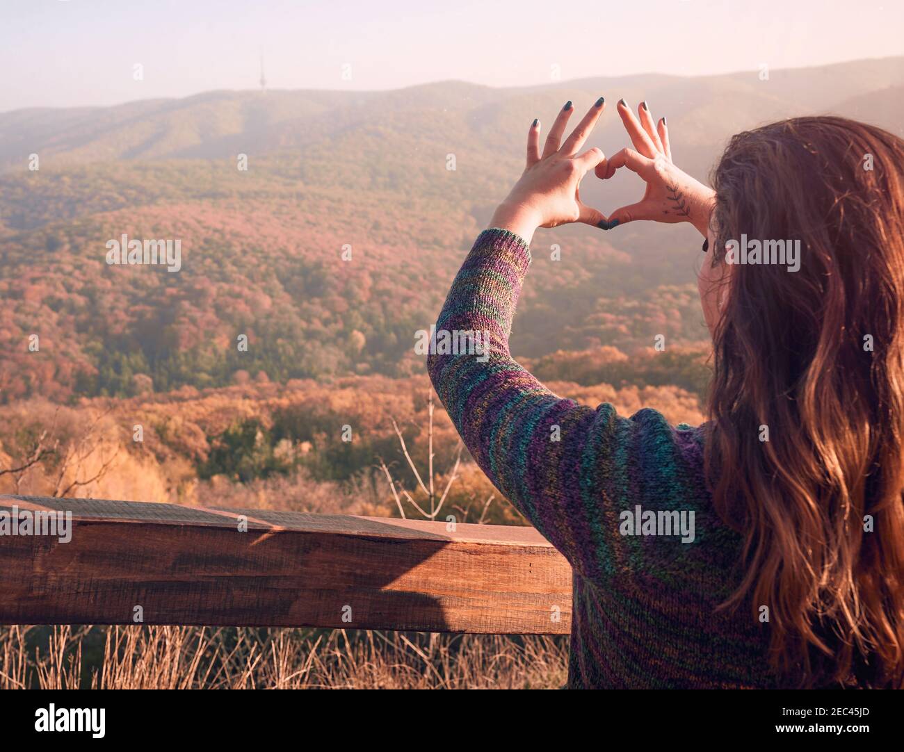 Woman making heart with her hands showing gratitude to nature and life ...