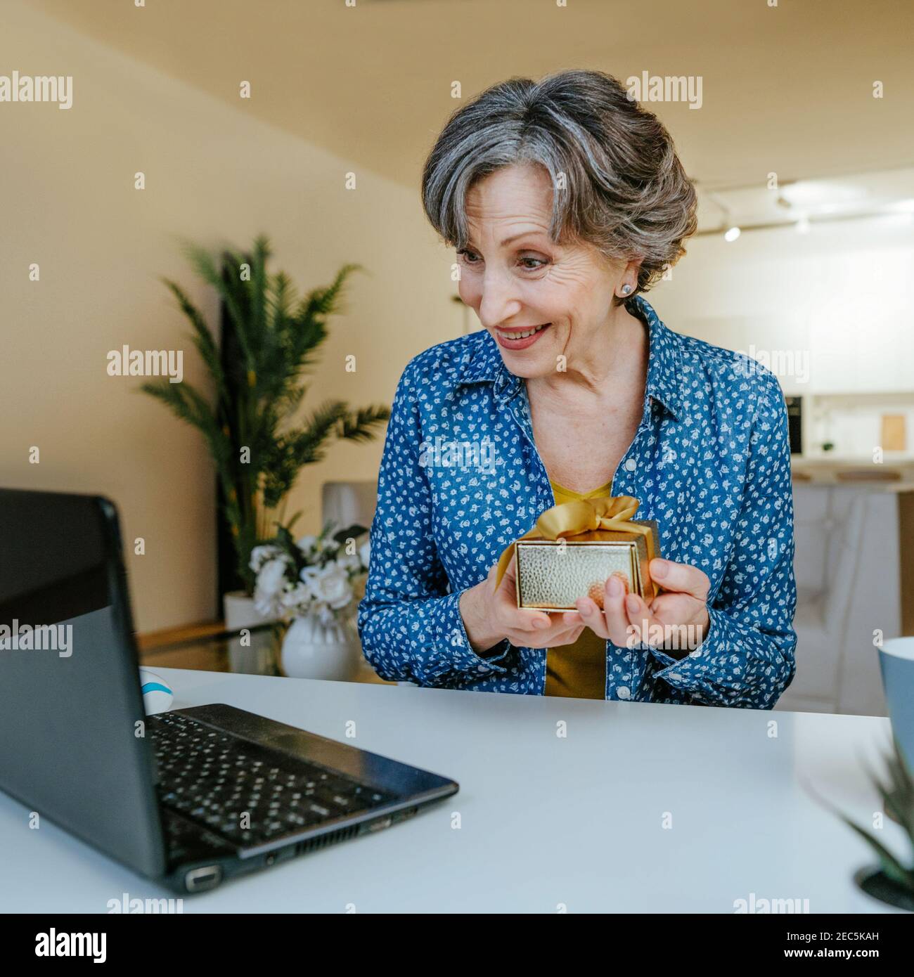 Portrait of a mature woman thanks for a gift by video call using a ...