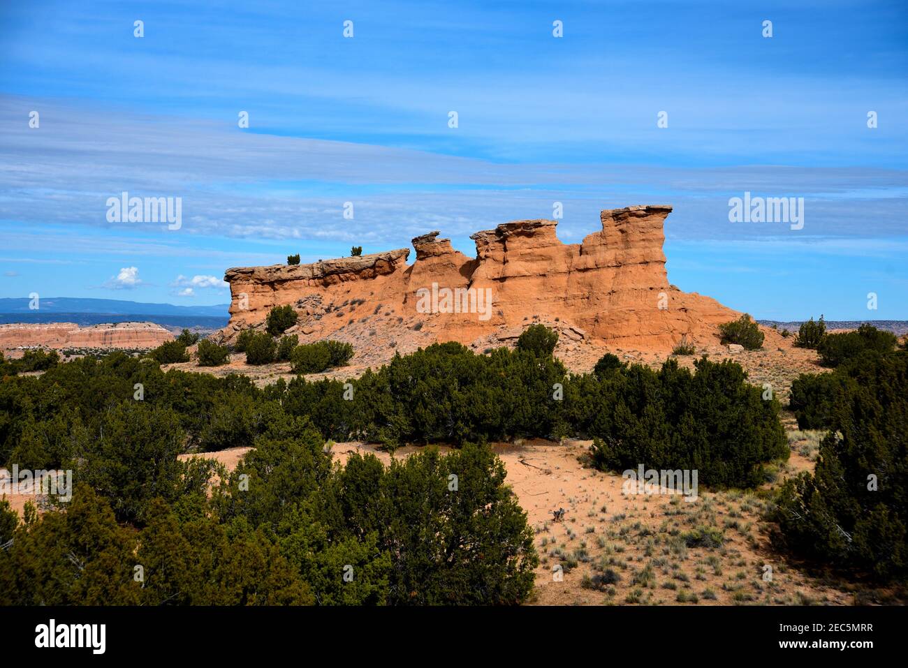 A scenic eroded geological feature surrounded by pinon trees near rural ...
