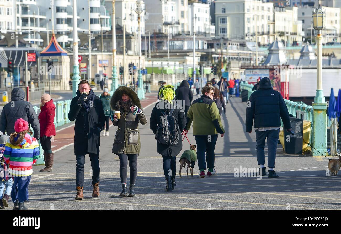 Brighton UK 13th February 2021 - Walkers are wrapped up warm on ...