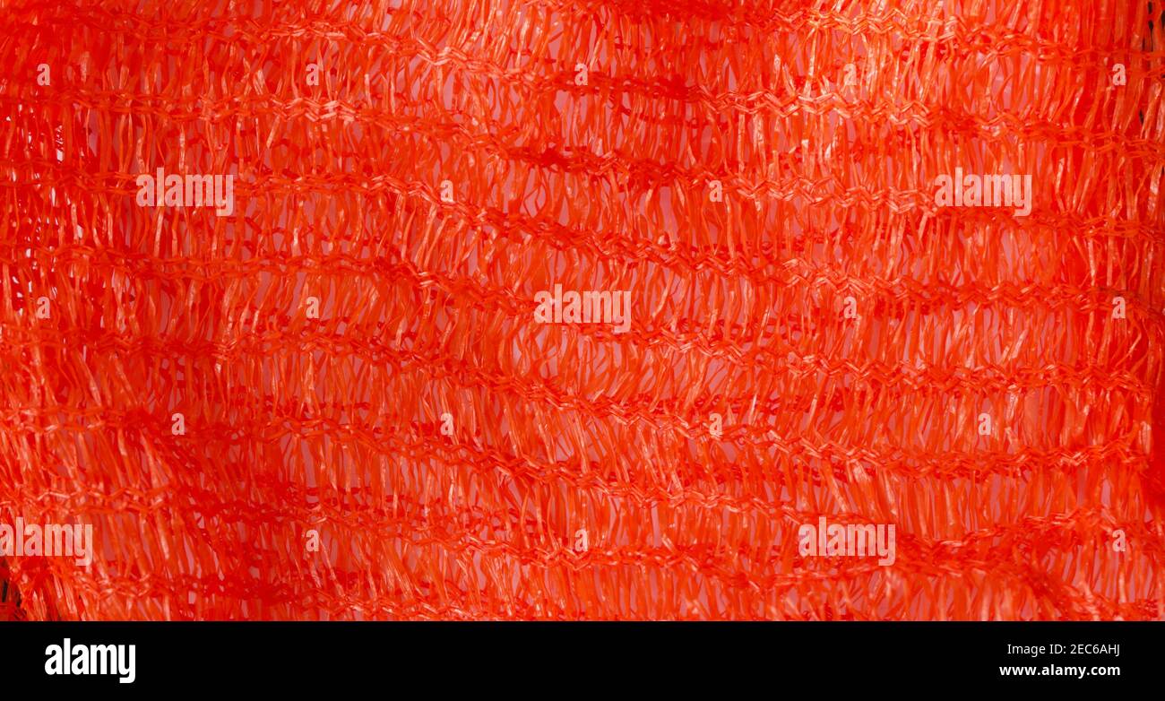 Full frame bright orange nylon netting textured background or wallpaper ...