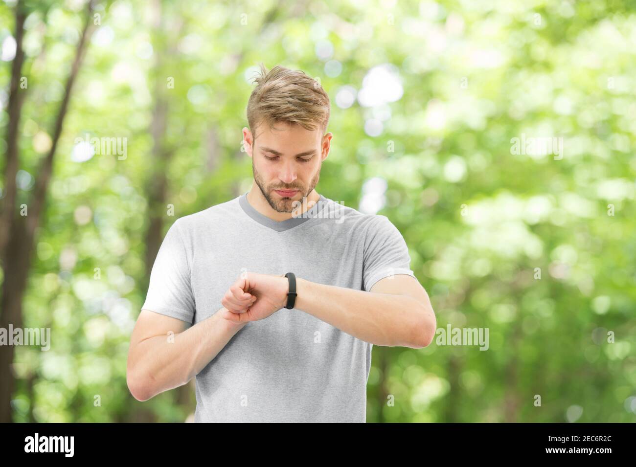Wearable technology. Handsome athlete using smartwatch technology ...