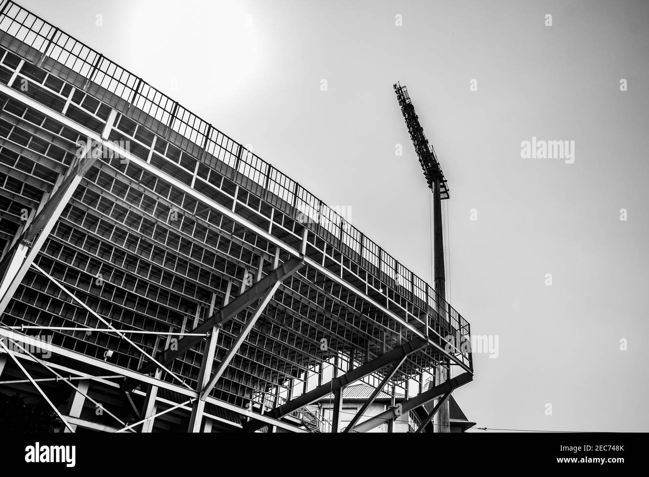 Grayscale shot of the upper part of the stadium with the under the dim ...