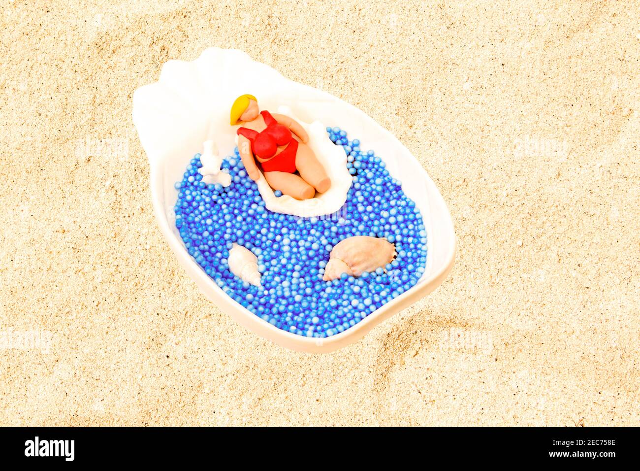 Handmade clay model on shell. Beach scene with artificial water and ...