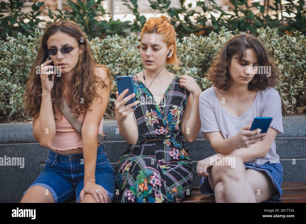 Alienation addiction. Group of girlfriends using smartphones together ...