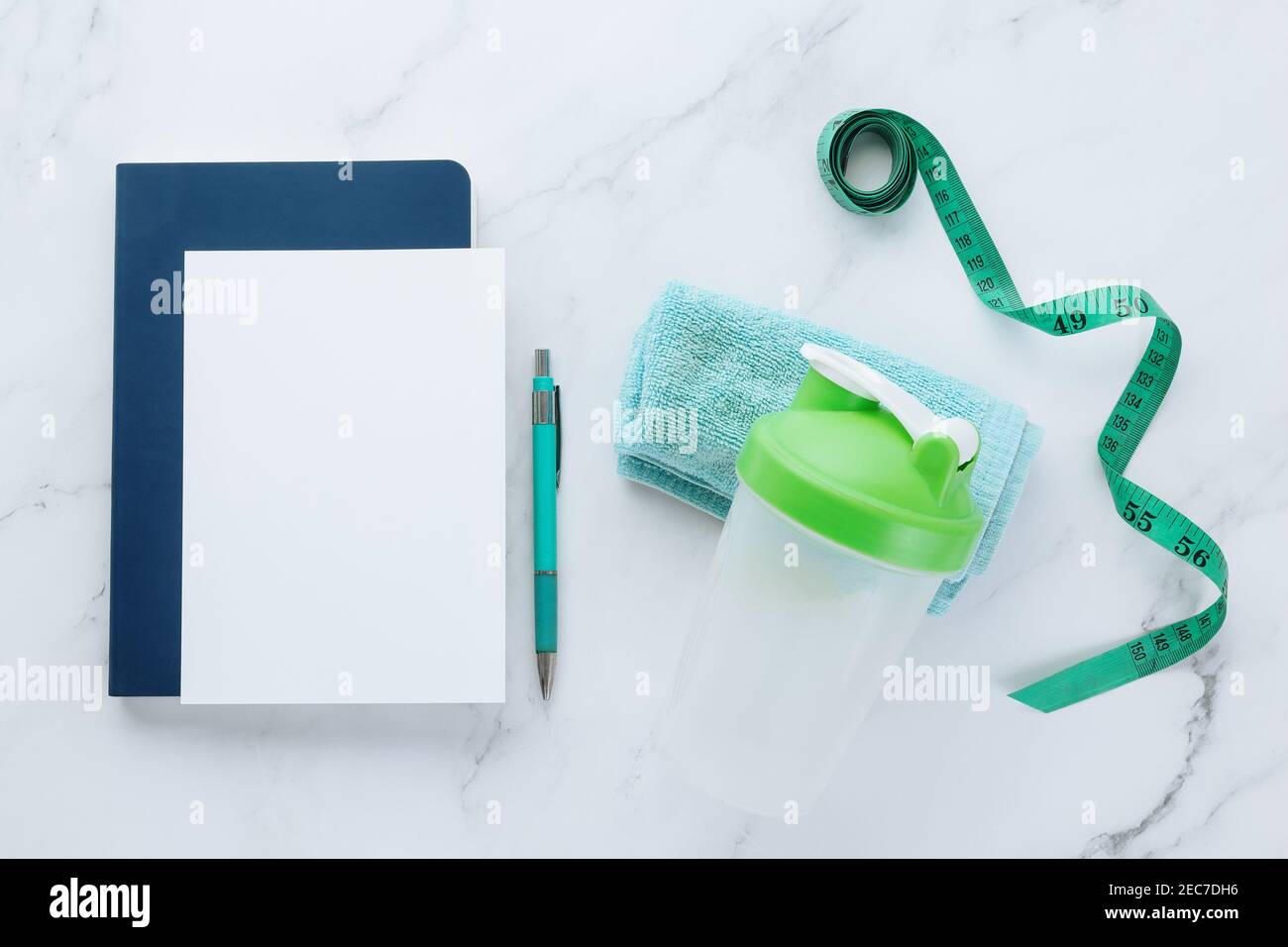 Blank white paper note and fitness equipments on white marble ...
