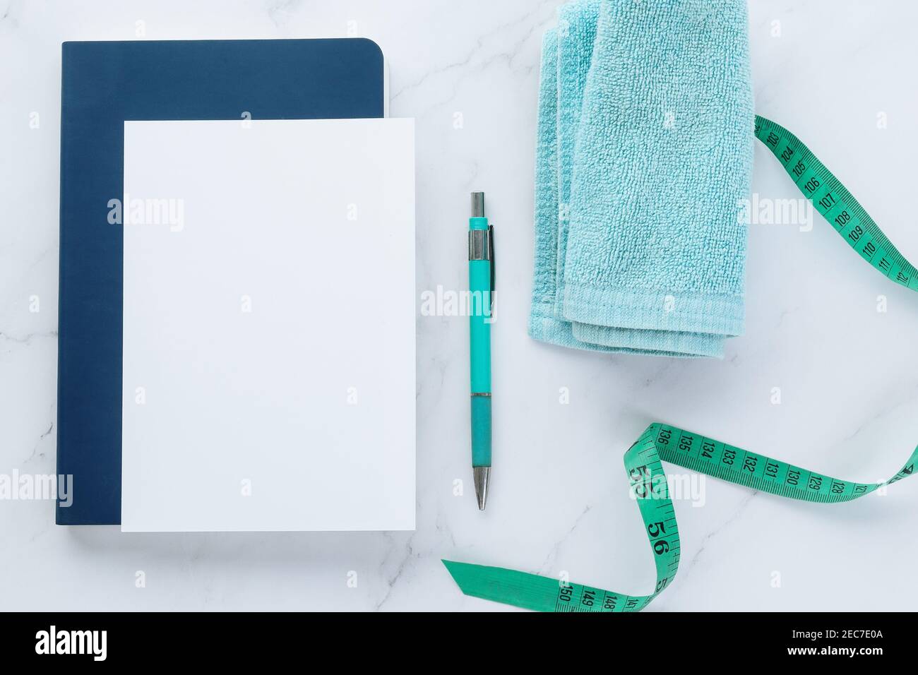 Blank white paper note and fitness equipments on white marble ...
