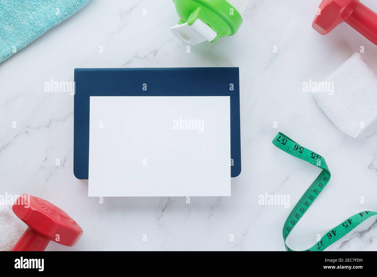 Blank white paper note and fitness equipments on white marble ...