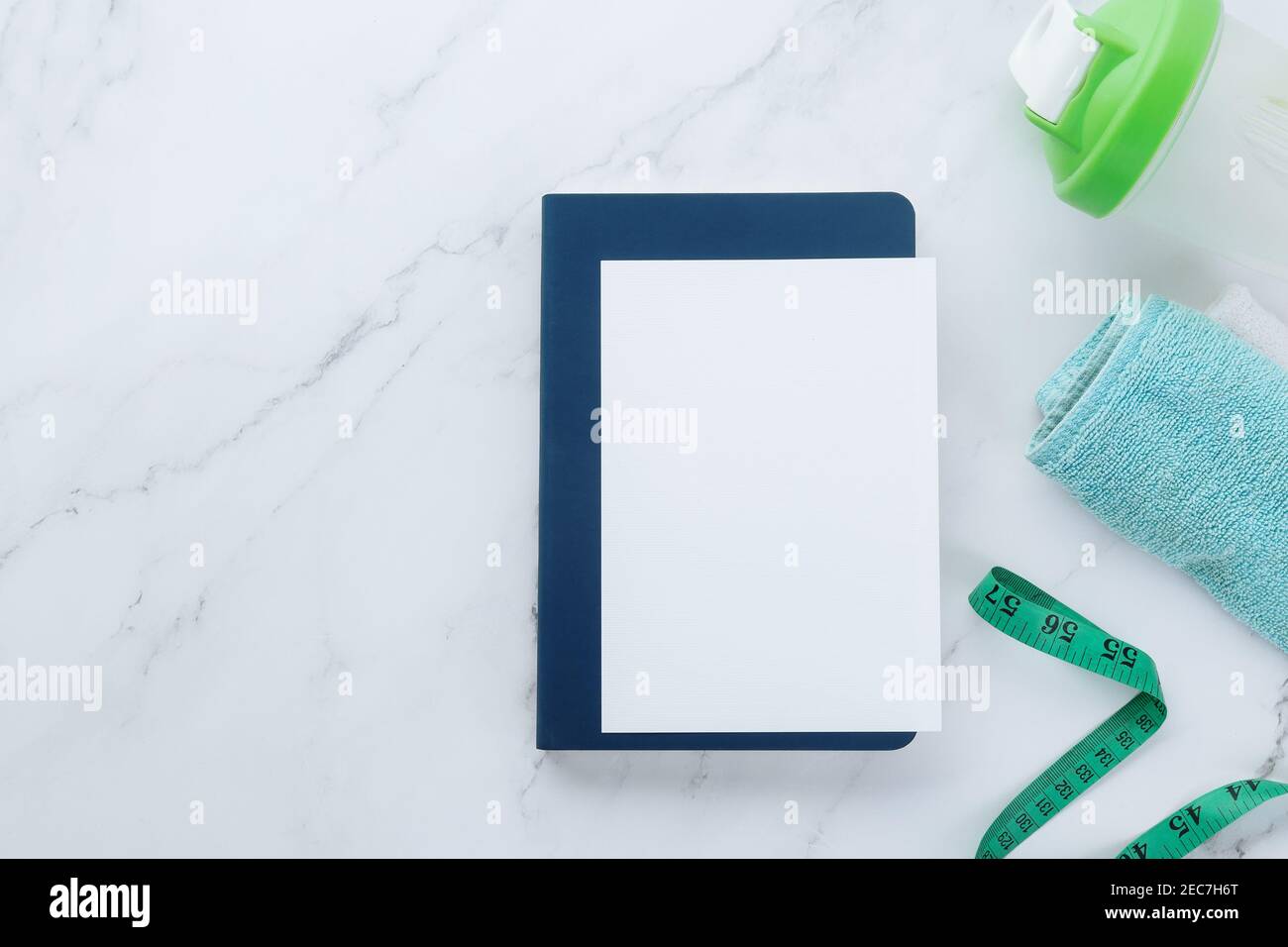 Blank white paper note and fitness equipments on white marble ...