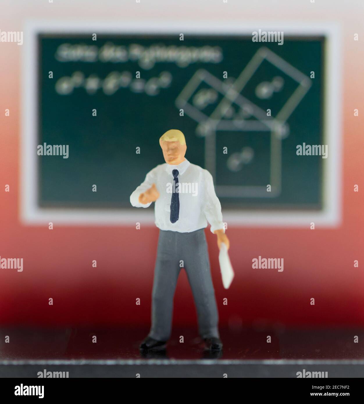 Man stands in front of chalkboard. Plastic puppet man in white shirt ...