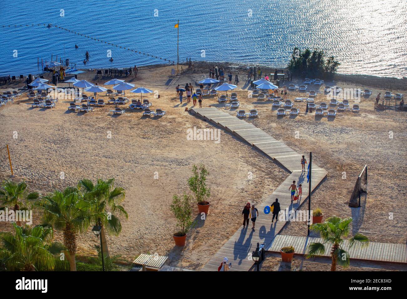 People floating and covered in black Dead Sea mud aat the beach of ...