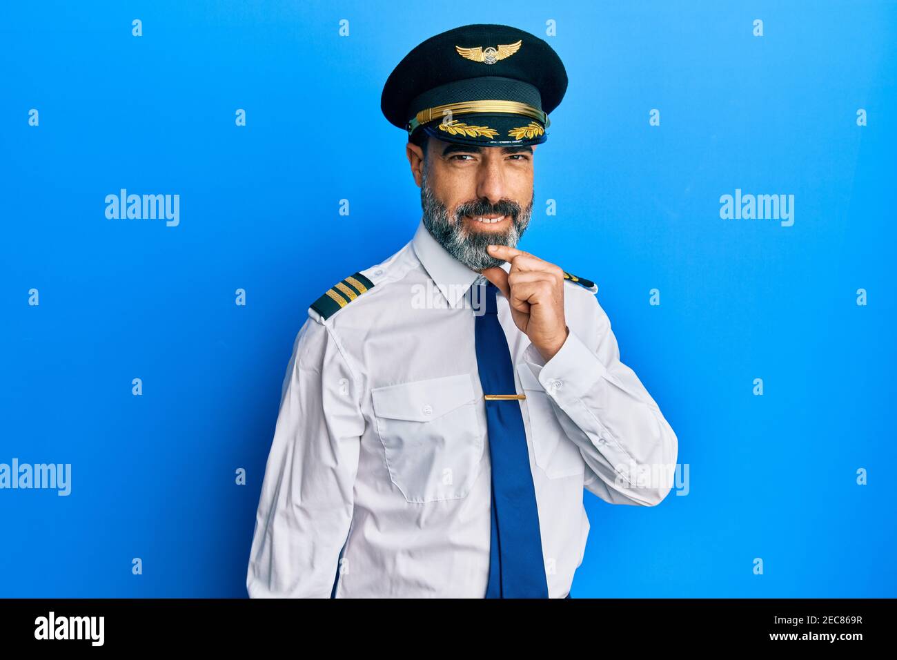 Middle age man with beard and grey hair wearing airplane pilot uniform ...