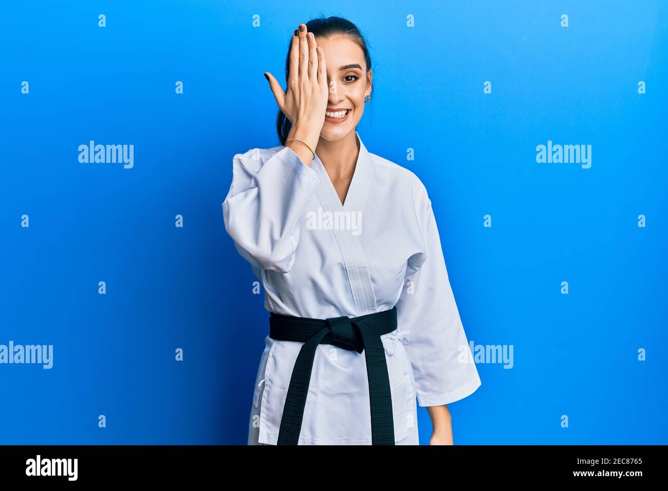 Beautiful brunette young woman wearing karate fighter uniform with ...