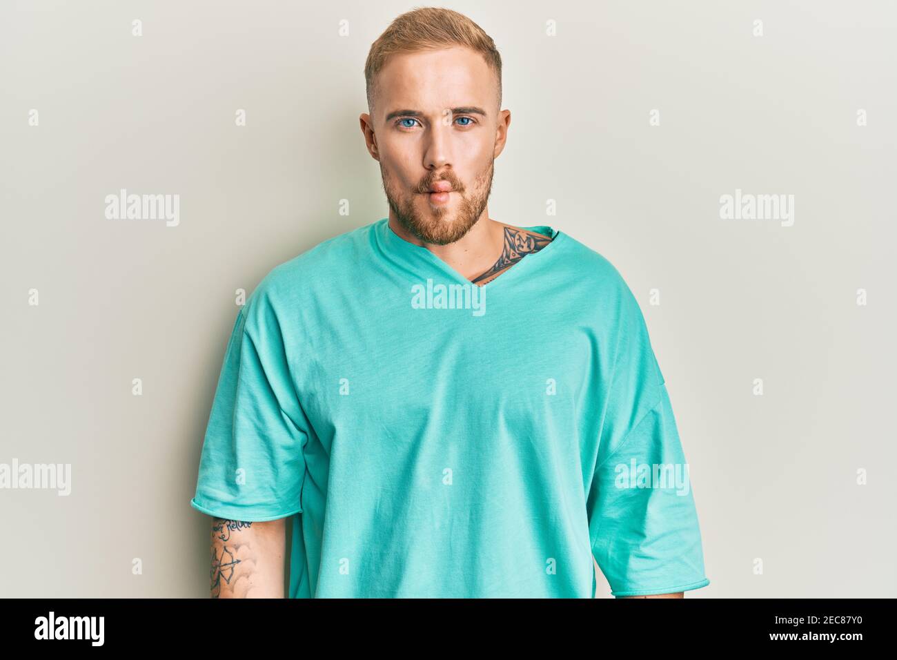 Young caucasian man wearing casual clothes making fish face with lips ...