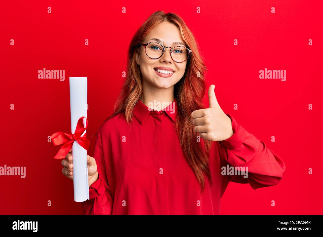Young redhead woman holding graduate degree diploma smiling happy and ...