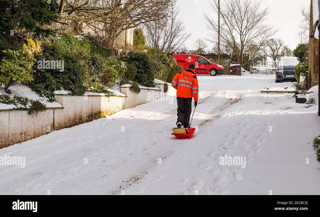 Royal Mail postman delivering parcels and letters in the post using a ...