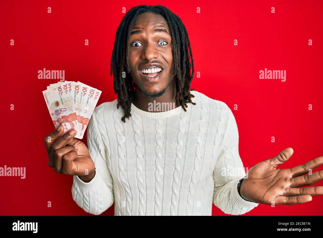 African american man with braids holding 10 colombian pesos banknotes ...