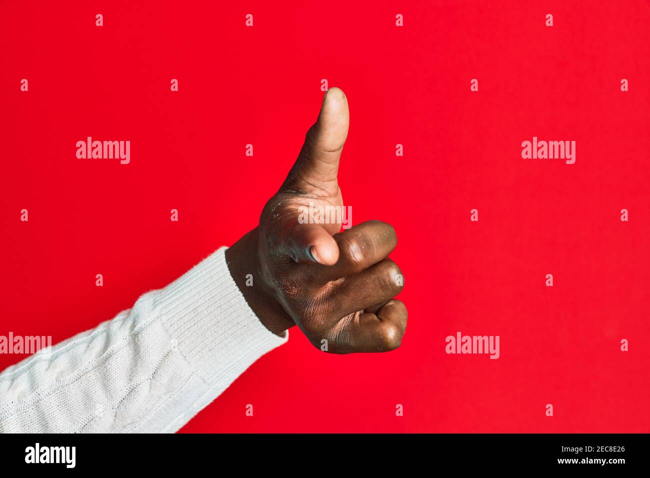 Arm and hand of african american black young man over red isolated background pointing ...