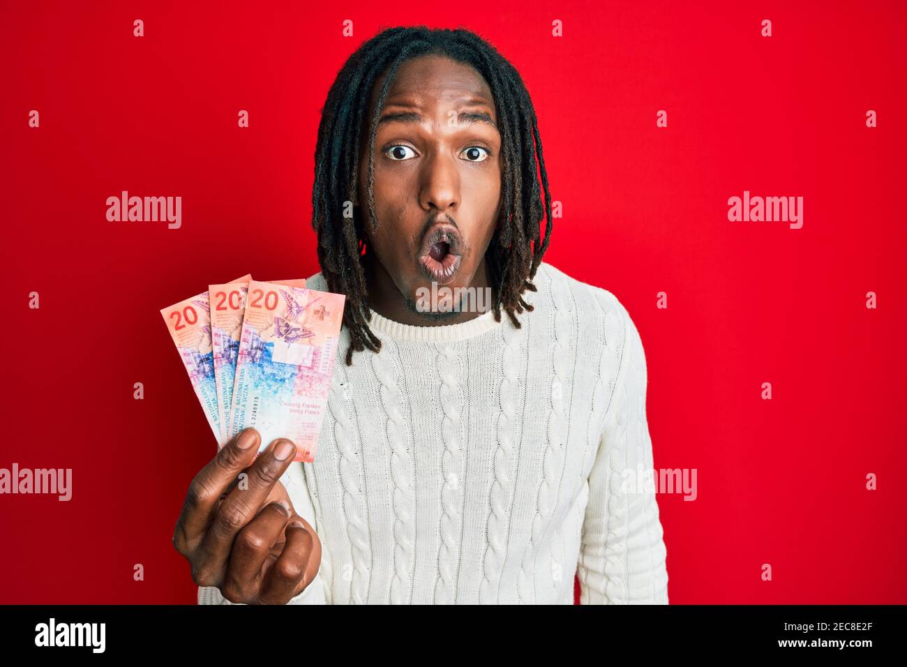 African american man with braids holding 20 swiss franc banknotes ...