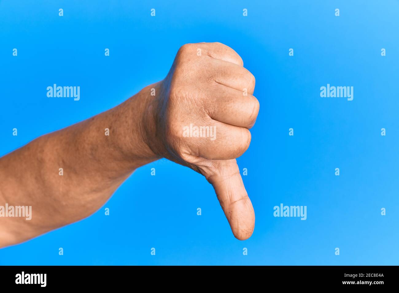 Hand of senior hispanic man over blue isolated background doing thumbs ...