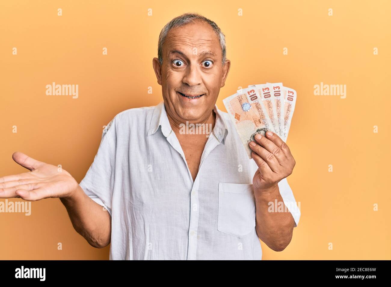 Handsome mature man holding 10 united kingdom pounds banknotes ...