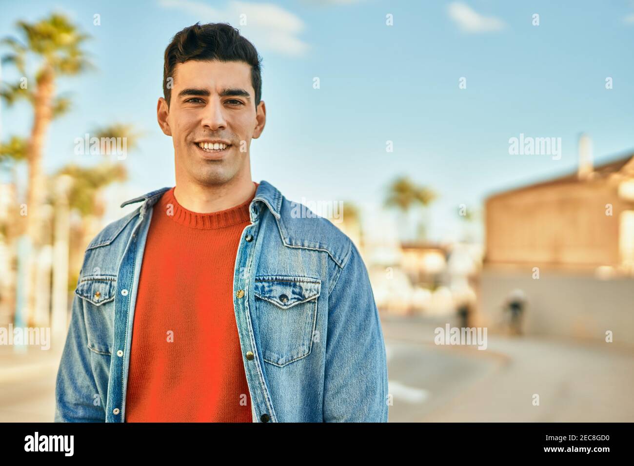 Young hispanic man smiling happy standing at the city Stock Photo - Alamy