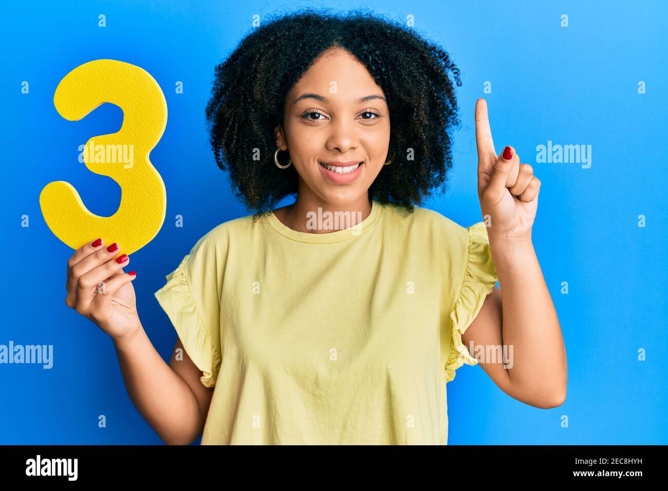 Young african american girl holding number three smiling with an idea ...