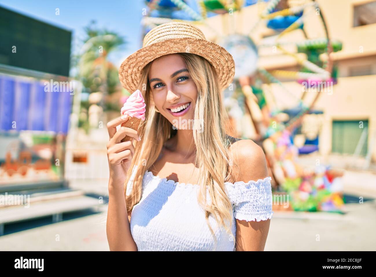 Young blonde tourist girl smiling happy eating ice cream at the ...