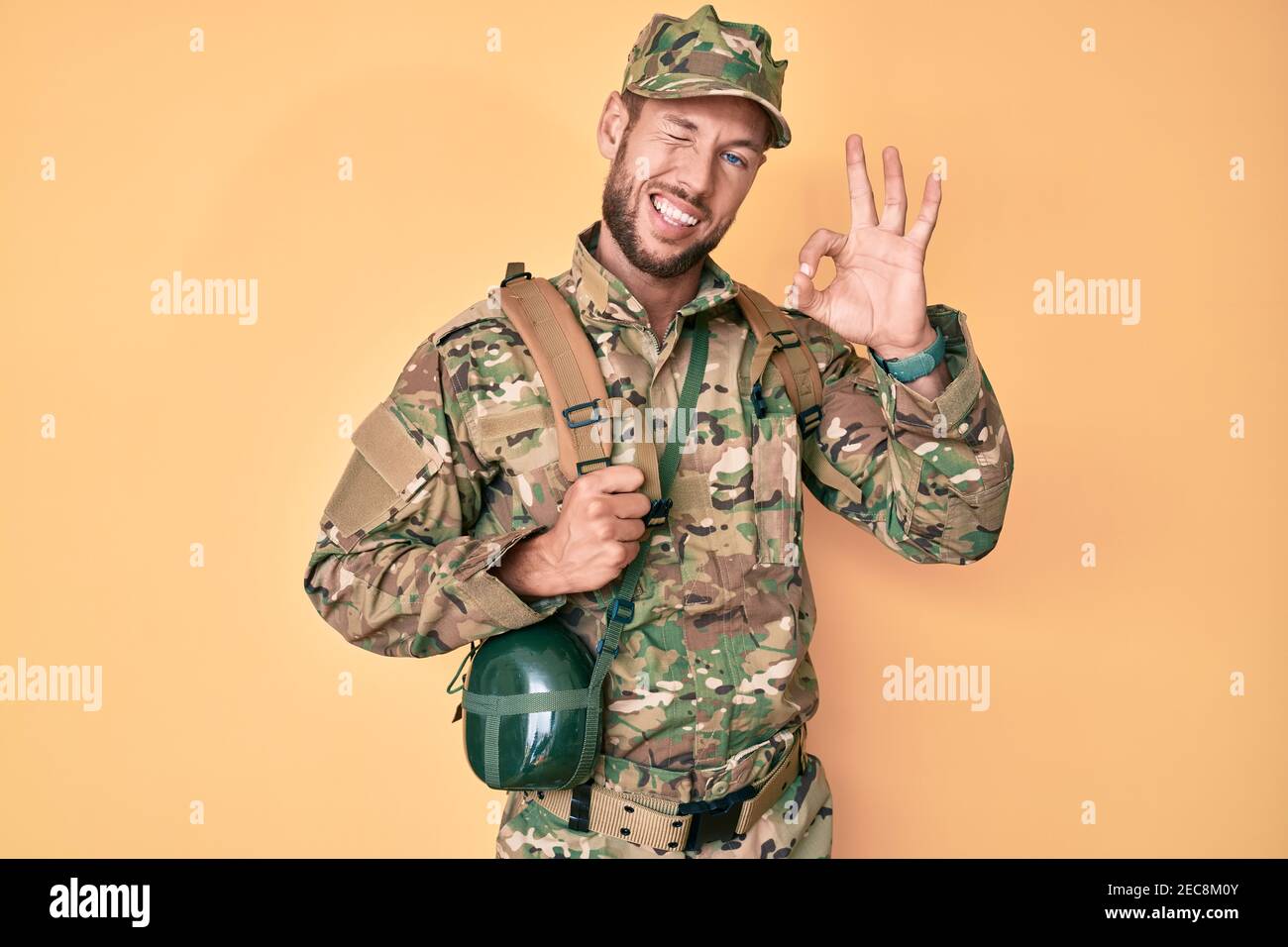 Young caucasian man wearing camouflage army uniform and canteen doing ...