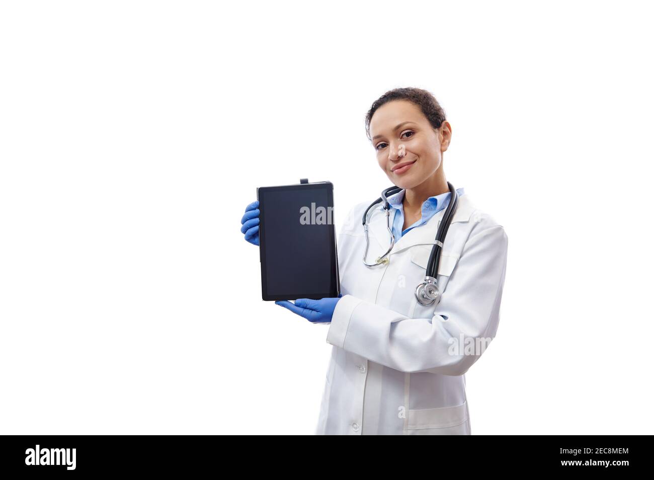 Smiling doctor holding tablet near her face and showing the screen to ...