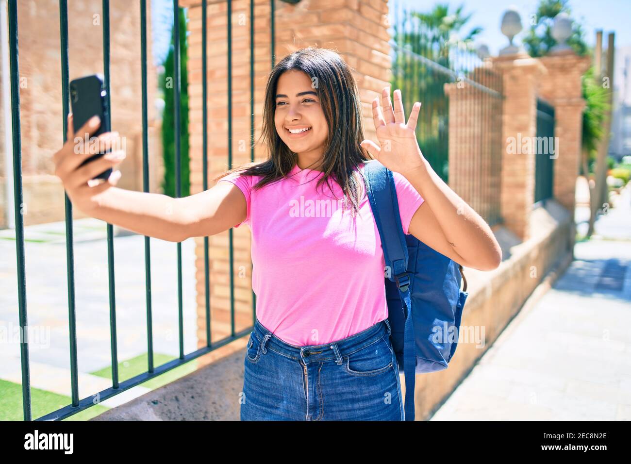 Young latin student girl doing video call using smartphone at ...