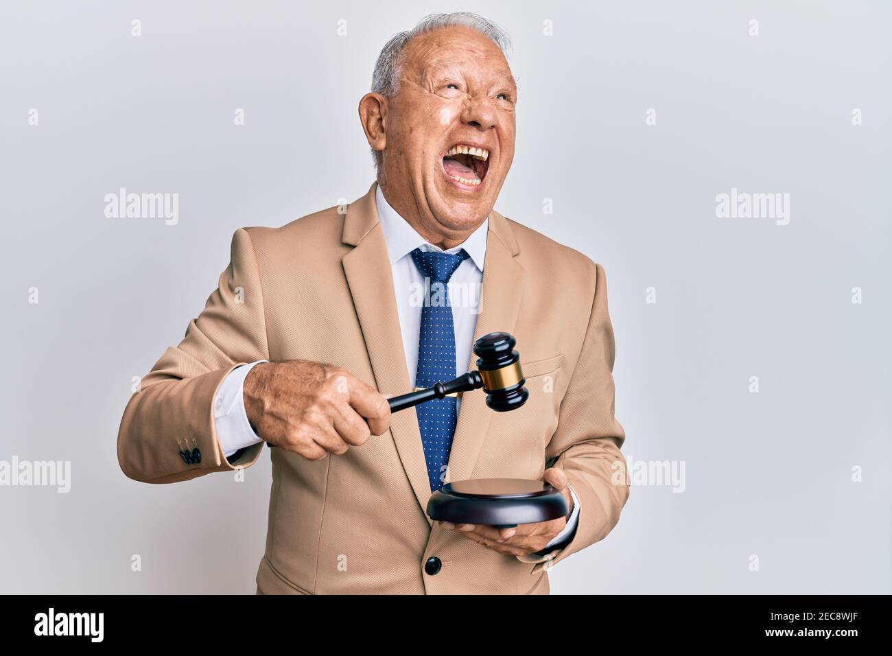 Senior caucasian judge man using gavel angry and mad screaming ...