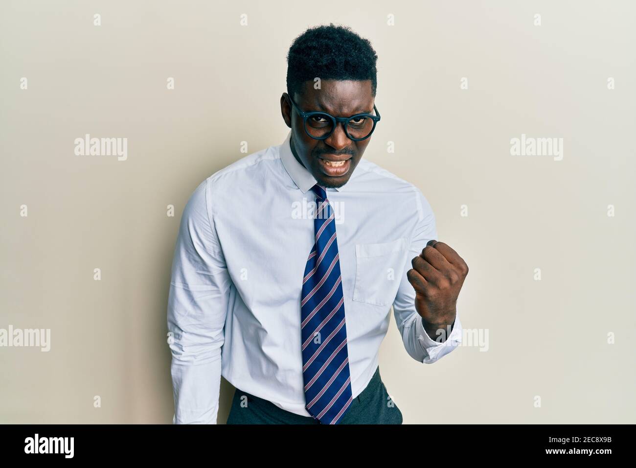 Handsome black man wearing glasses business shirt and tie angry and mad ...