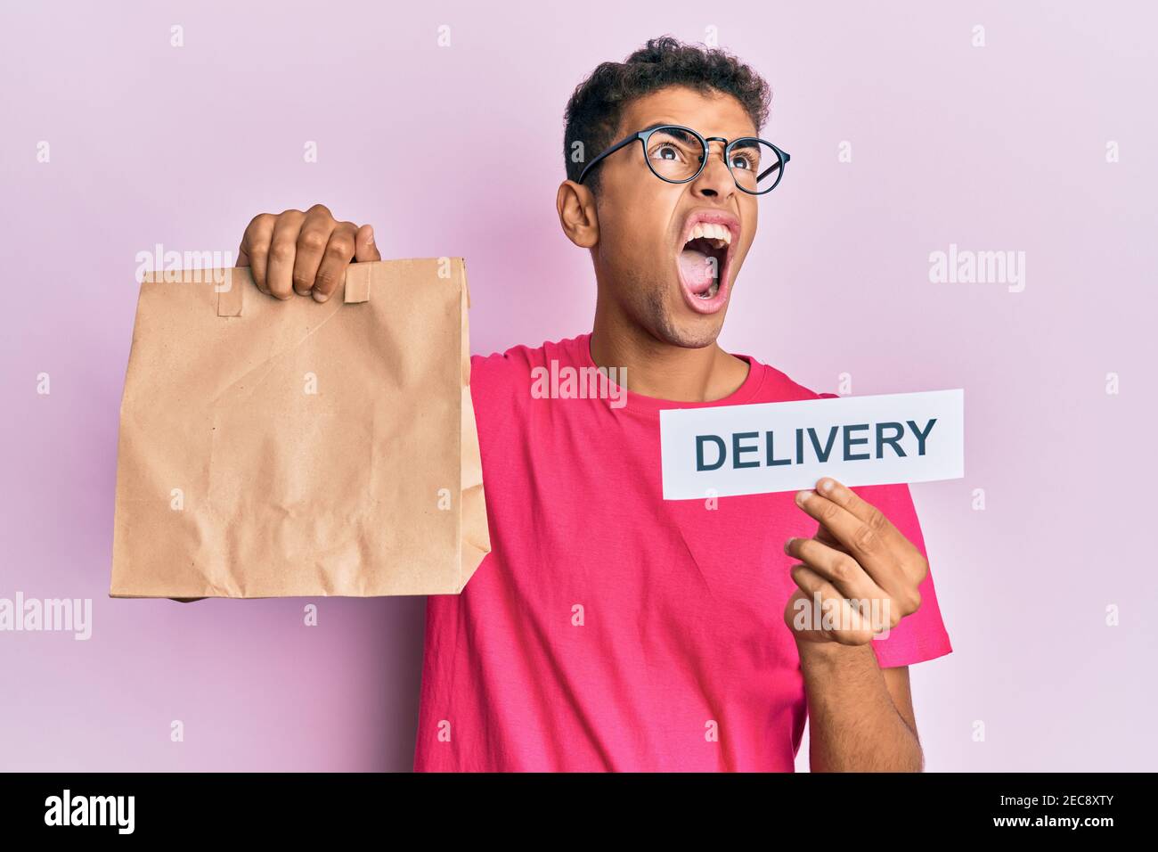 Young handsome african american man holding take away paper bag with ...
