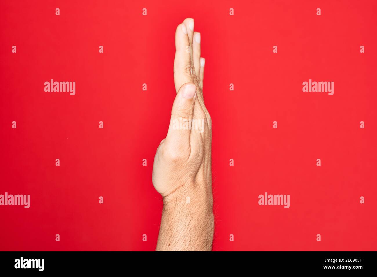 Hand of caucasian young man showing fingers over isolated red ...