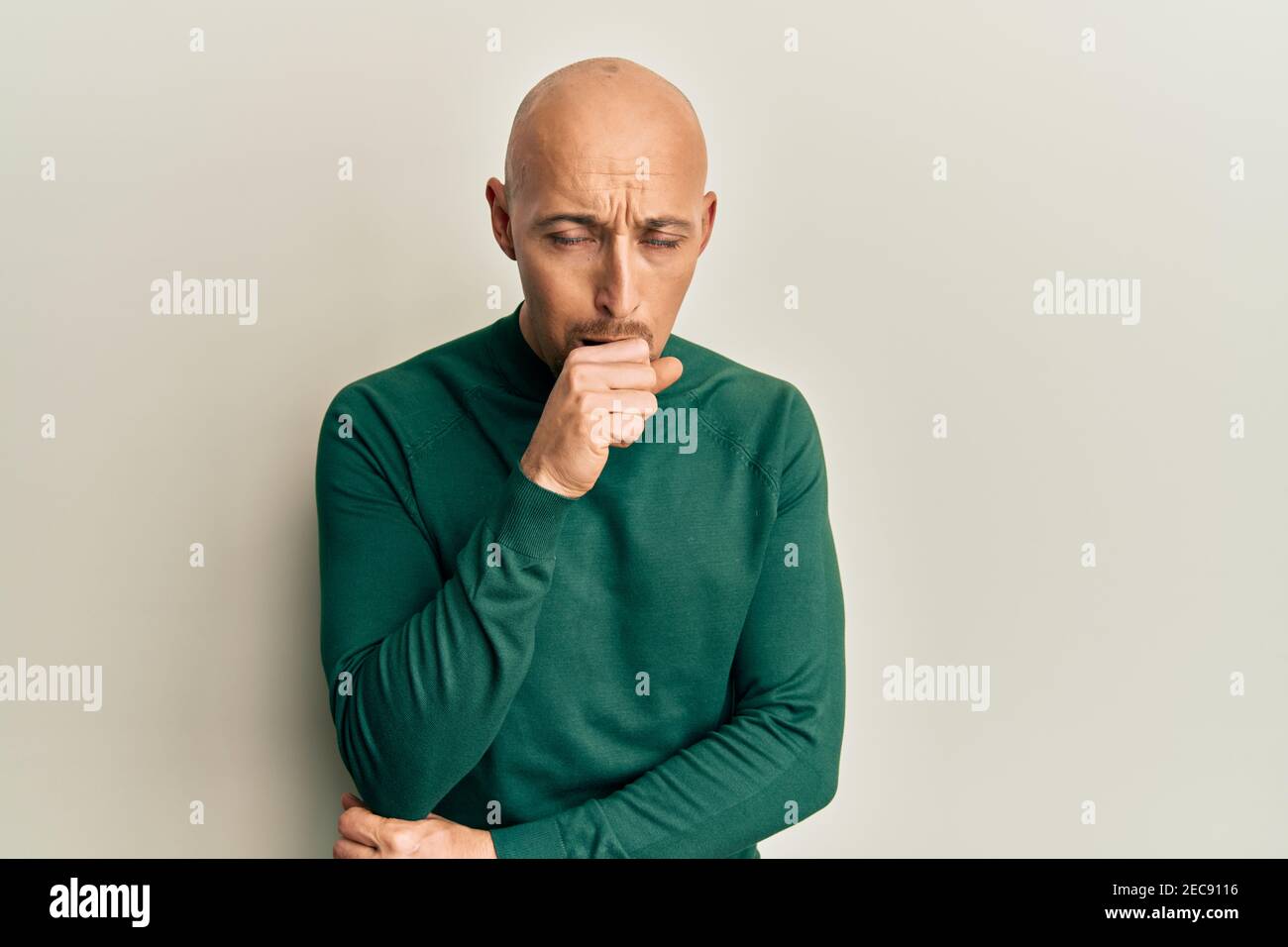 Bald man with beard wearing casual turtleneck sweater feeling unwell ...