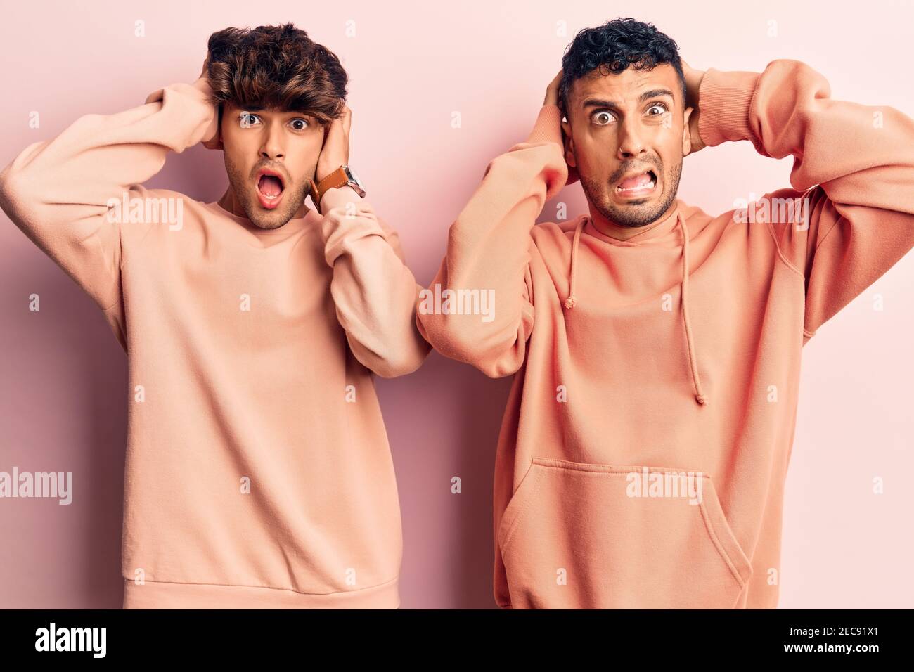 Young gay couple wearing casual clothes crazy and scared with hands on ...