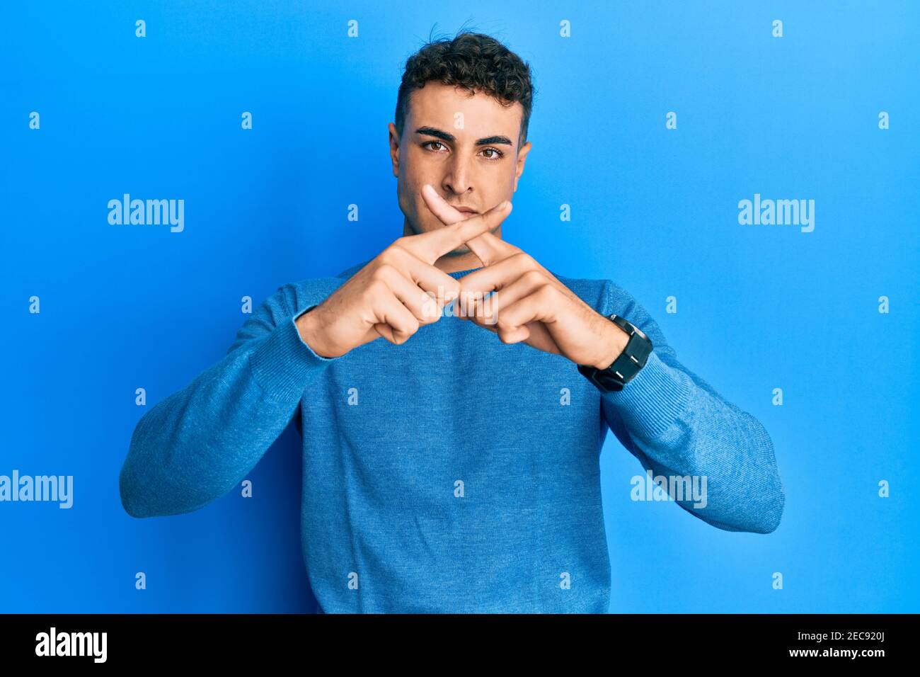 Hispanic young man wearing casual winter sweater rejection expression ...