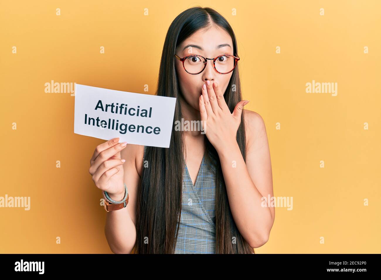 Young chinese woman holding artificial intelligence paper covering ...