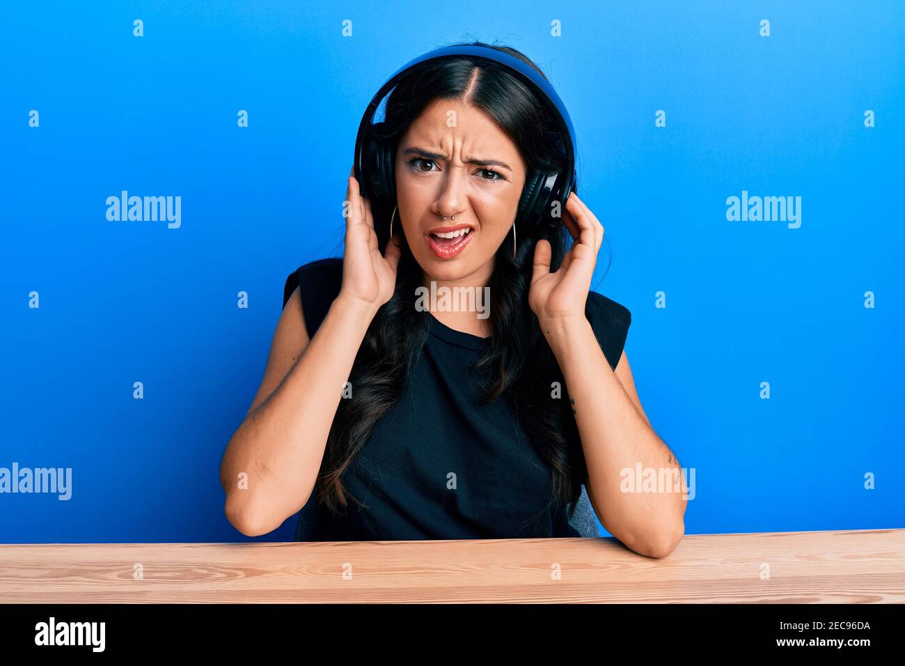 Beautiful brunette young woman listening to music using headphones in ...