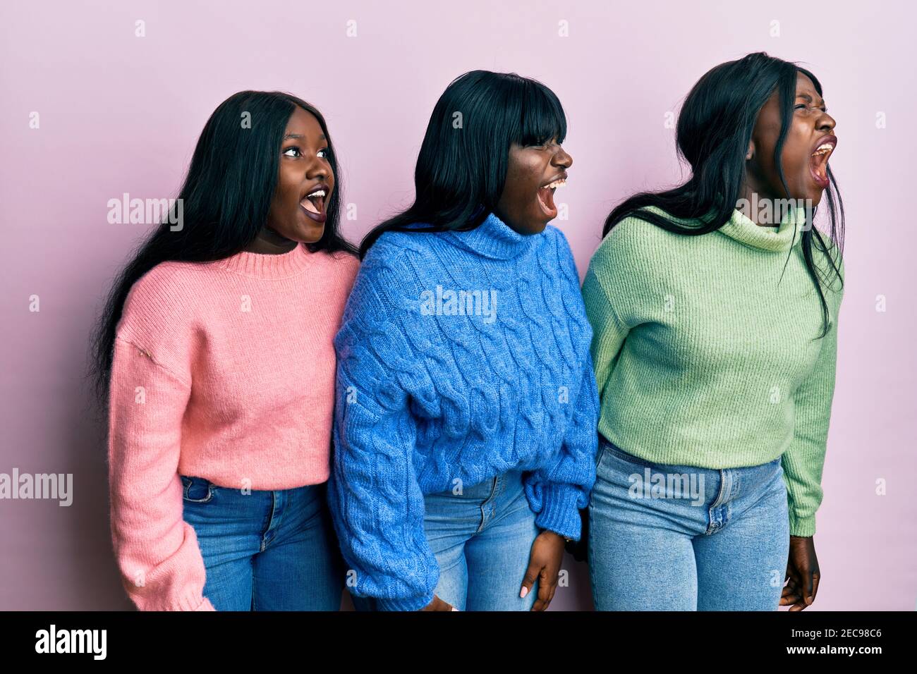 Three young african american friends wearing wool winter sweater angry ...